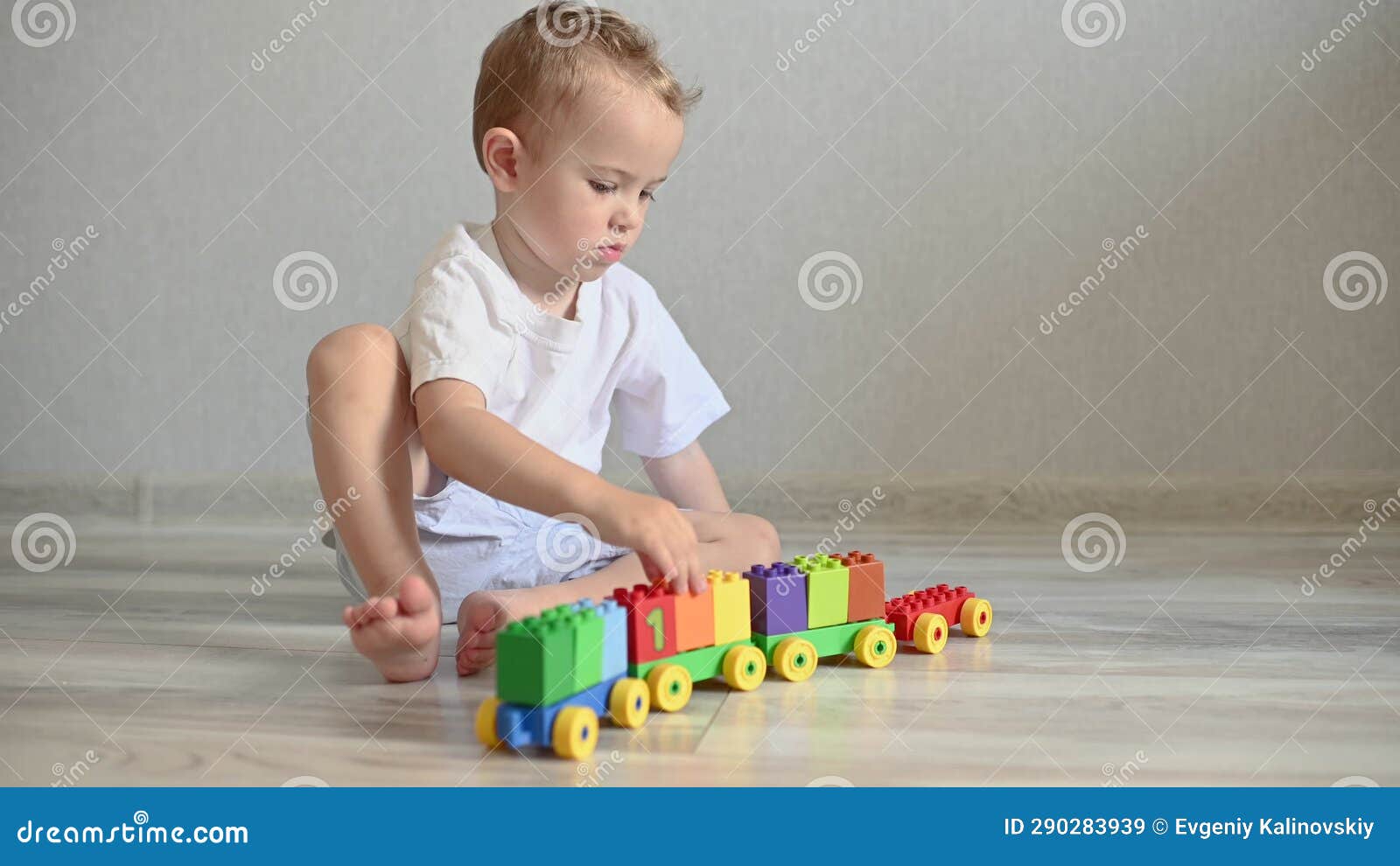 The Kid is Playing a Train with Trailers from the Constructor with ...