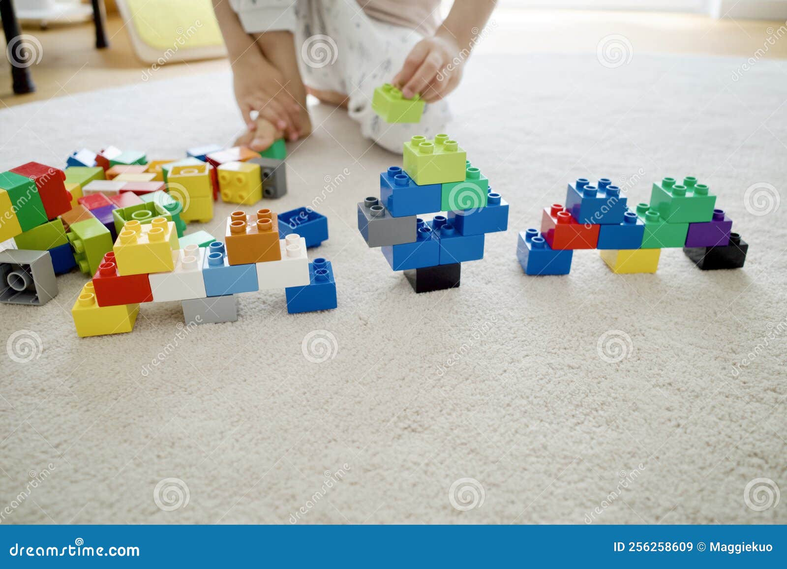 A Kid Plays Building Blocks on a White Carpet. Stock Image - Image of ...