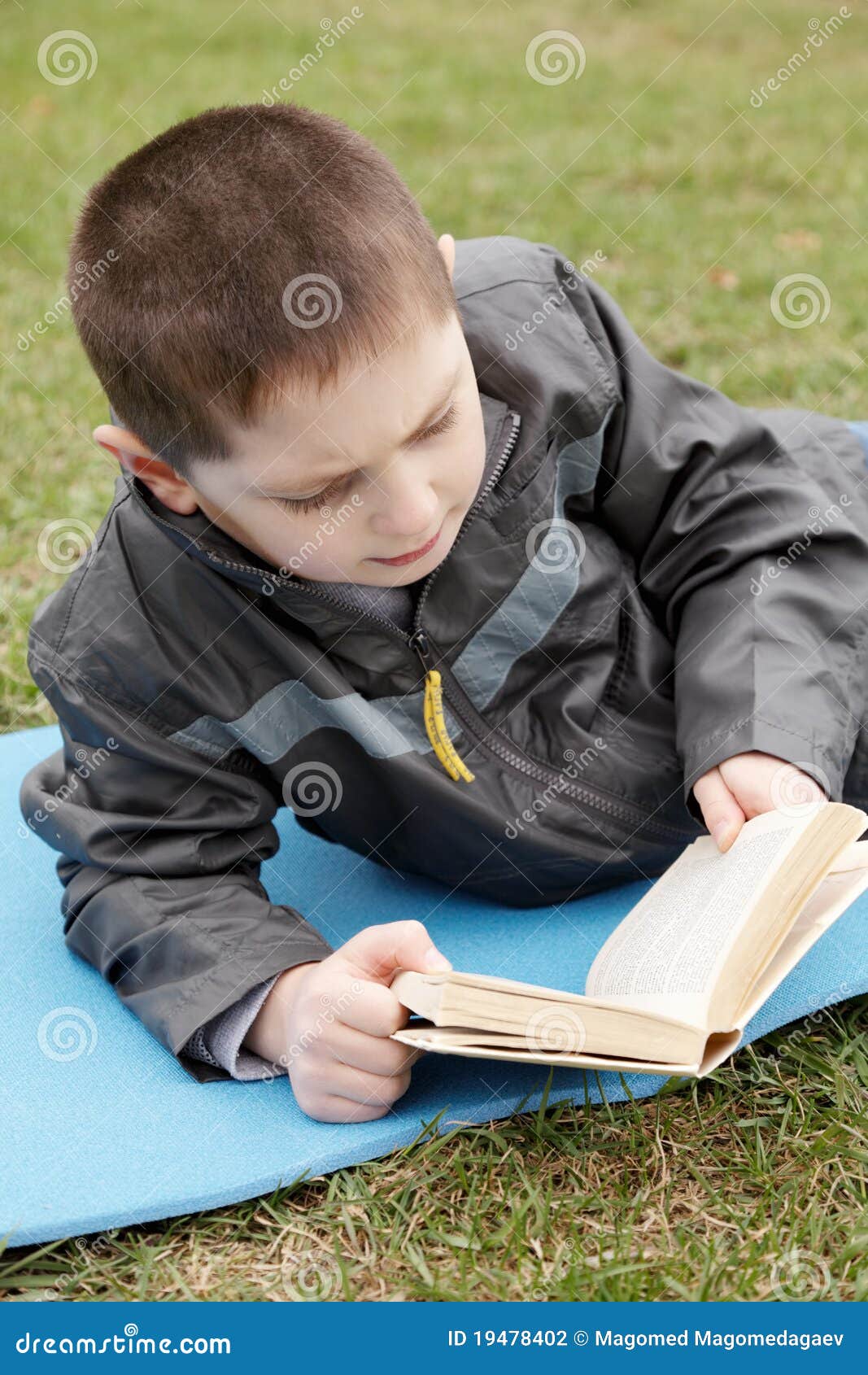 Kid reading book outdoors stock photo. Image of jacket - 19478402