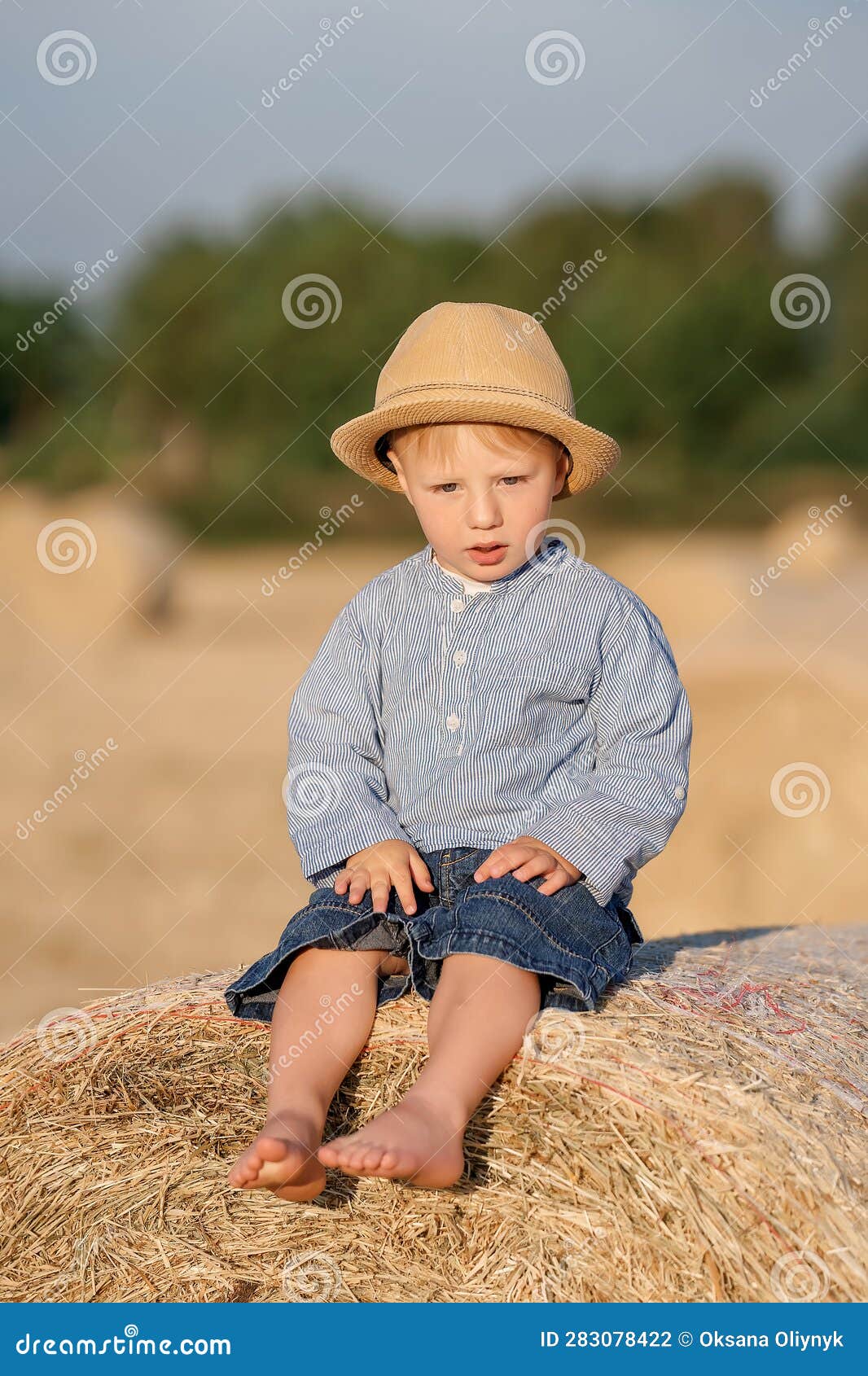 A Kid in Rural Clothes Sits on the Hay. Stock Photo - Image of portrait ...