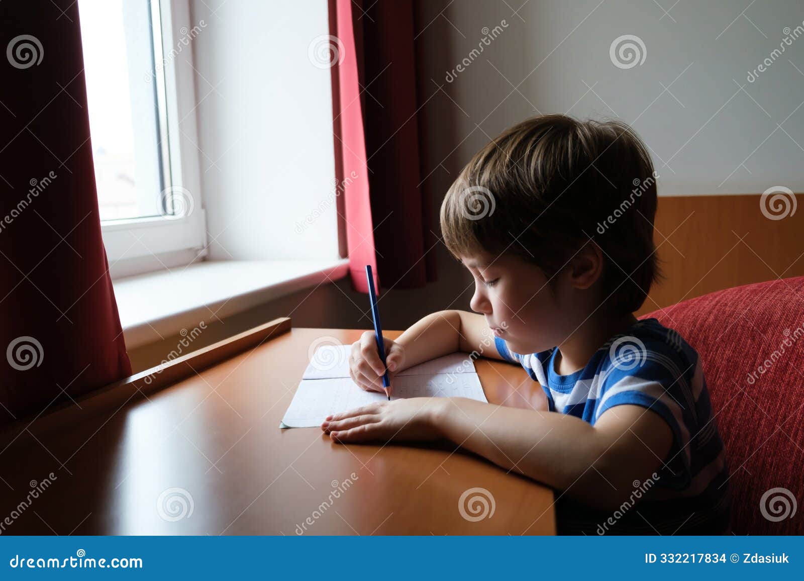 The Kid is Sitting at the Table and Doing Homework. the Child Writes ...