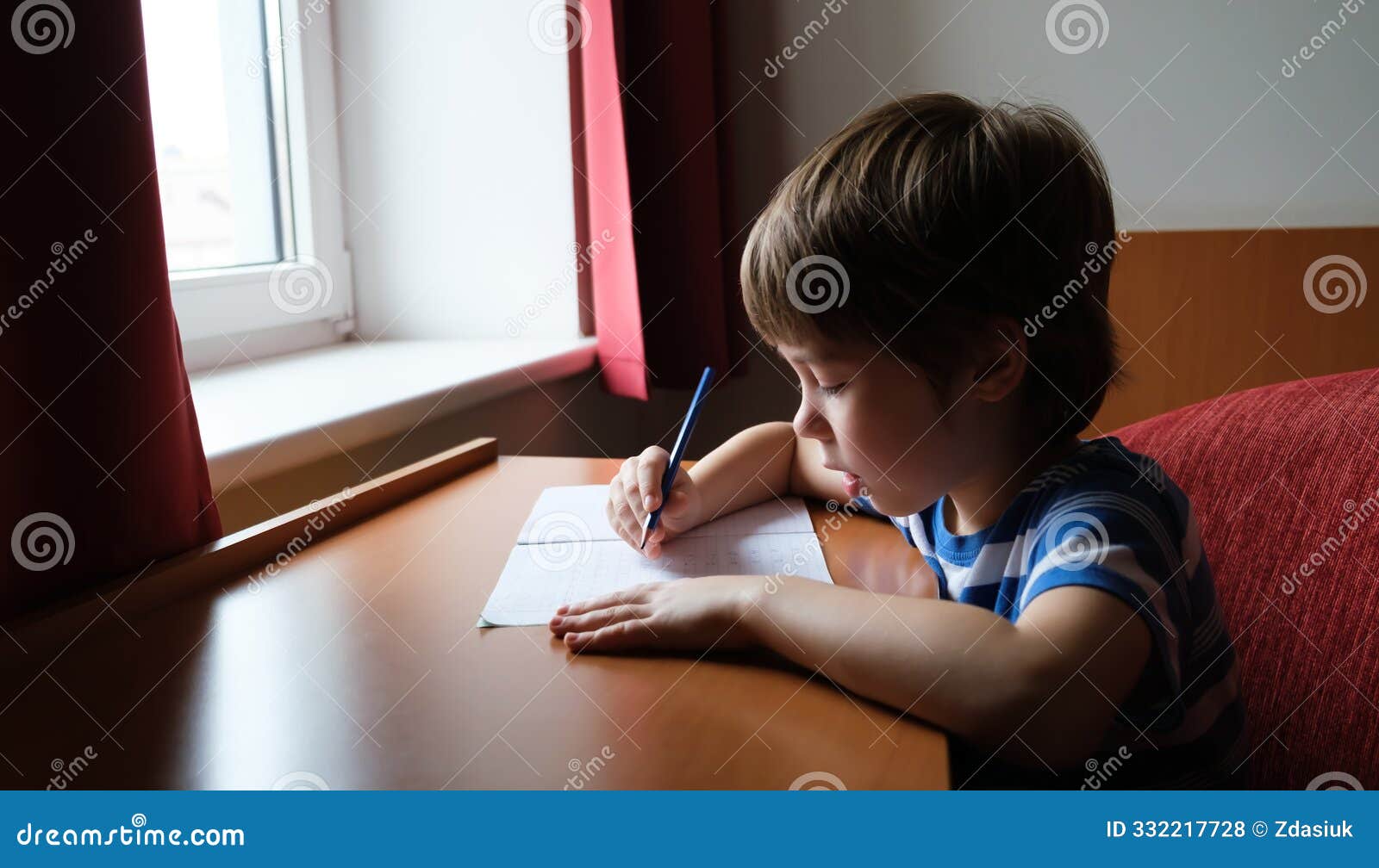 The Kid is Sitting at the Table and Doing Homework. the Child Writes ...