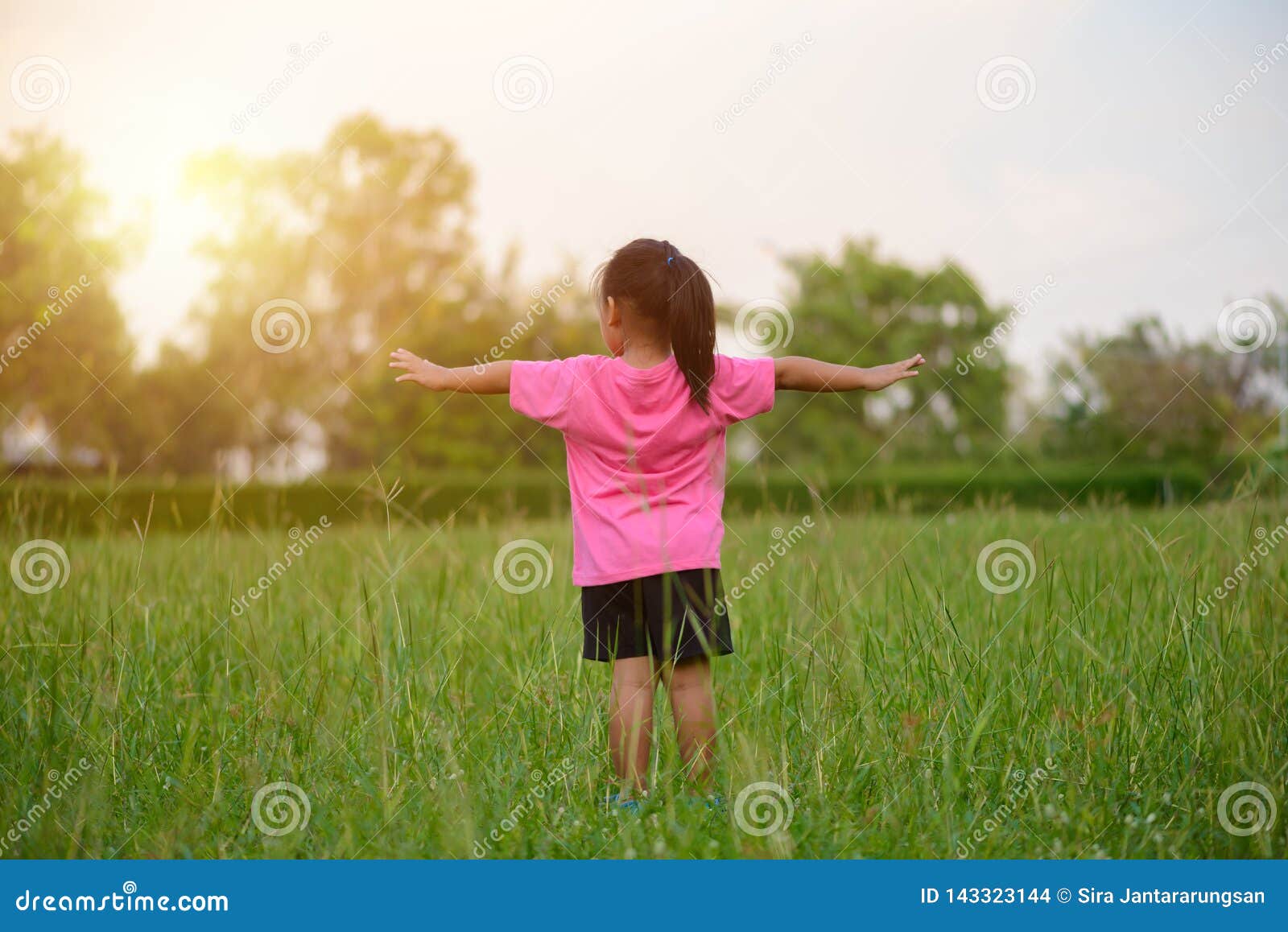 Kid Standing and Stretch the Arms or Extend Arms in the Grass Fields ...