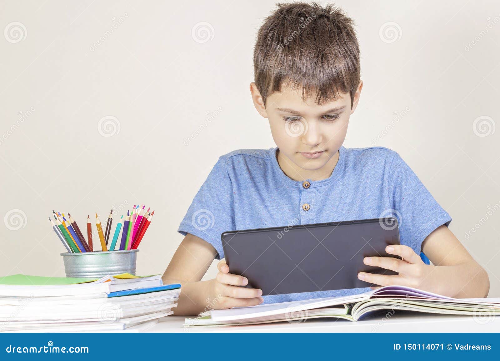 Kid with Tablet Computer Sitting at Table with Books Notebooks Stock ...