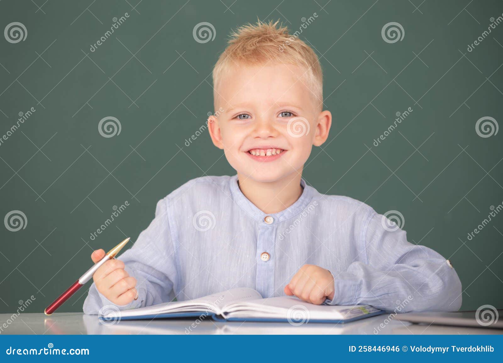 Kid Writing in Notebook in Class. Little Schoolboy Study in a Classroom ...
