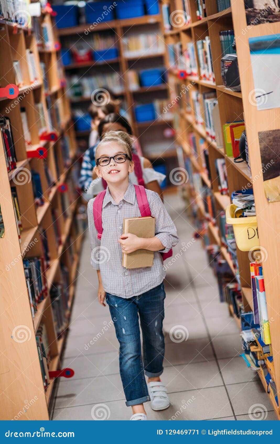 Kids with books in library stock image. Image of school - 129469771