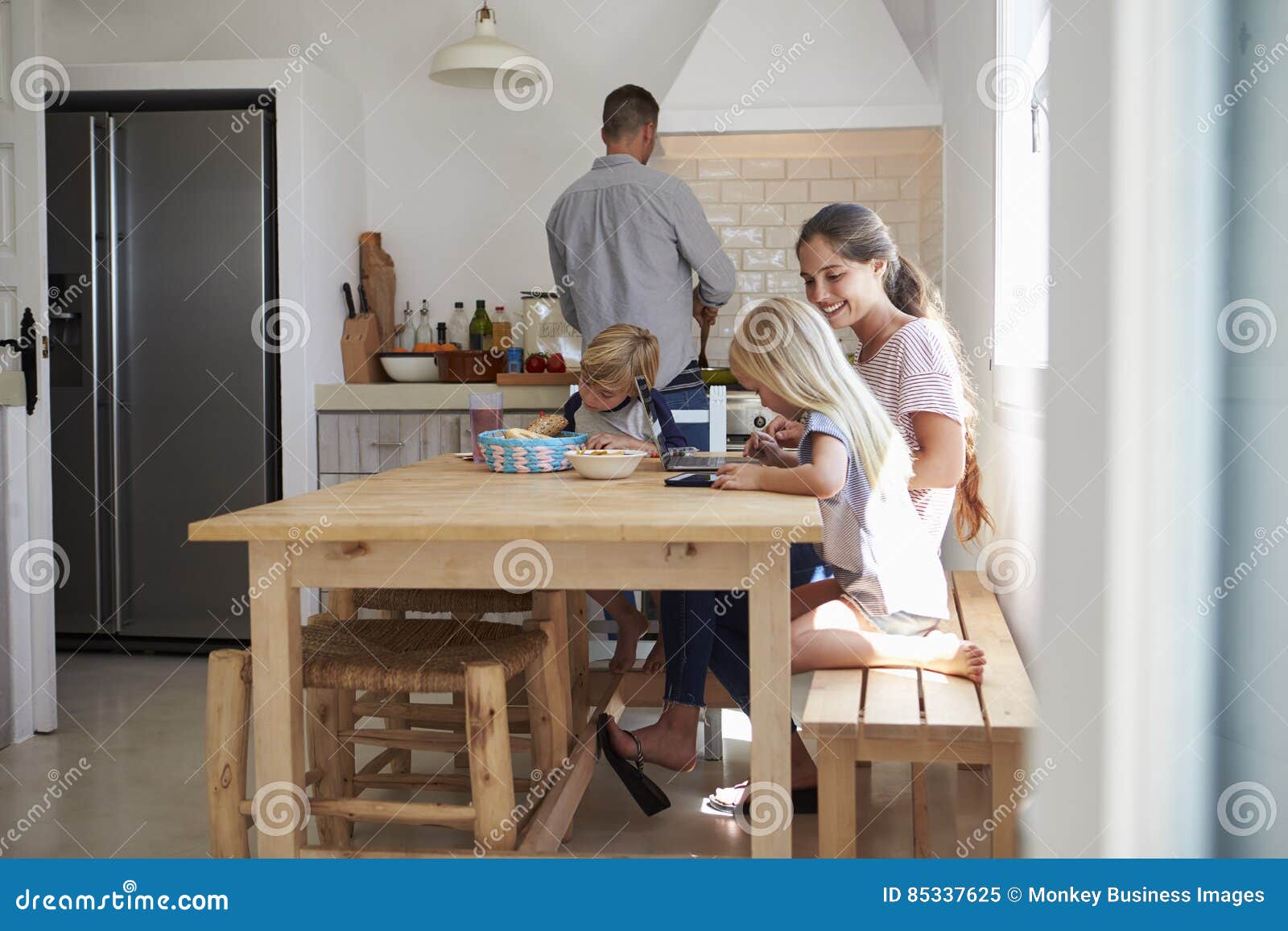 Kids Do Homework at Kitchen Table with Mum while Dad Cooks Stock Image ...