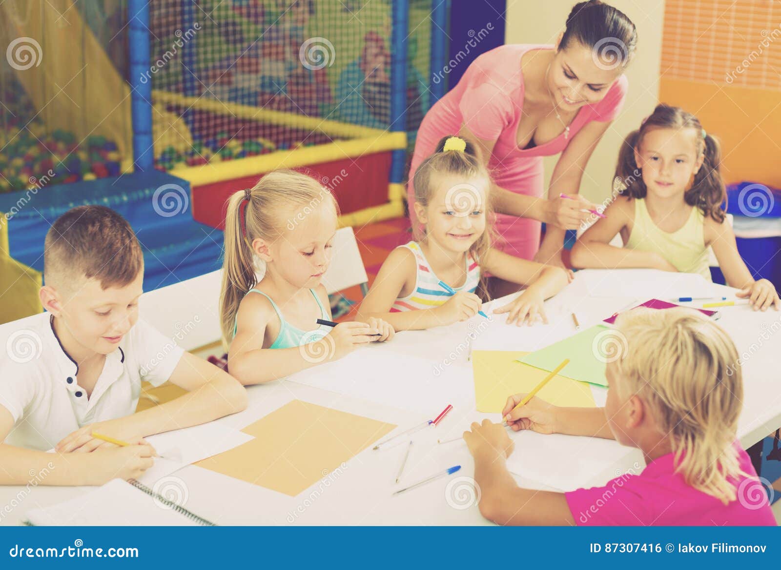 Kids Drawing on Lesson in Classroom with Help of Teacher Stock Photo ...