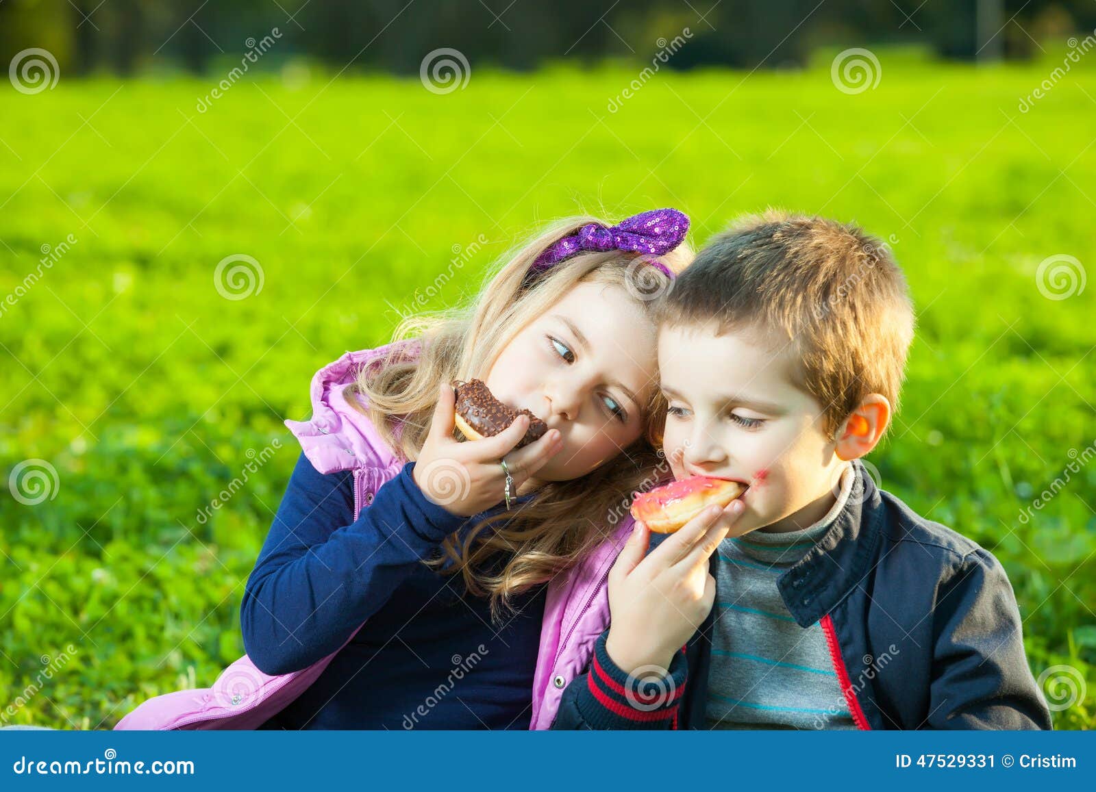 Kids eating donuts stock image. Image of girl, grass - 47529331