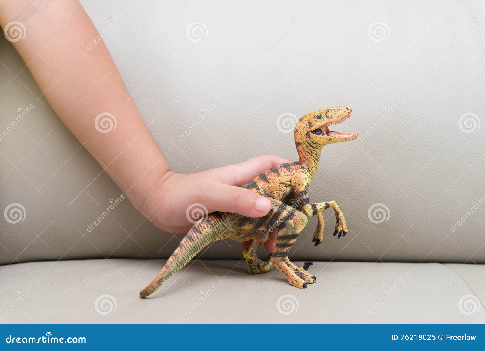 Kids Hand Catching a Velociraptor Toy on a Sofa Stock Image - Image of ...