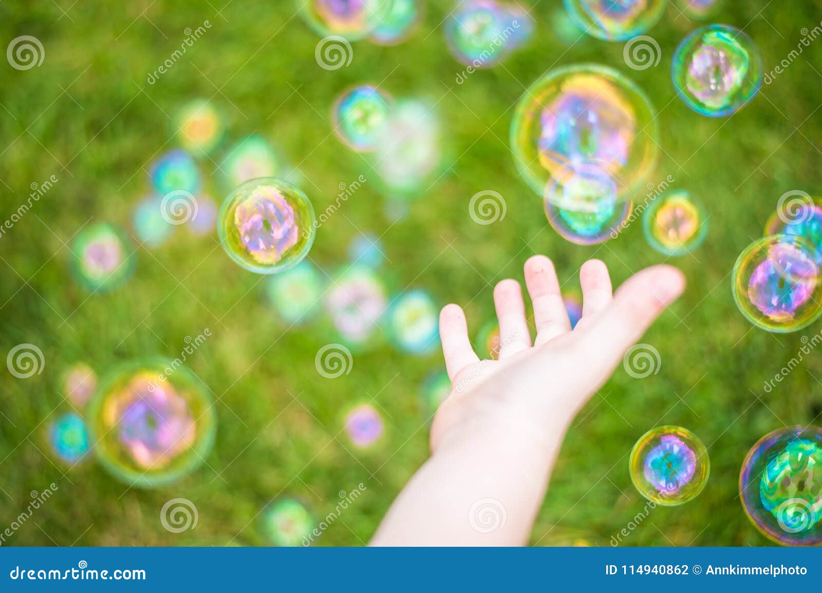 Kids Hands Catching Bubbles with Fresh Green Grass at a Background ...