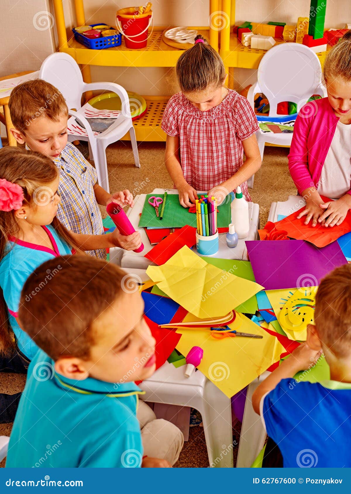 Kids Holding Colored Paper on Table in Stock Photo - Image of hand ...