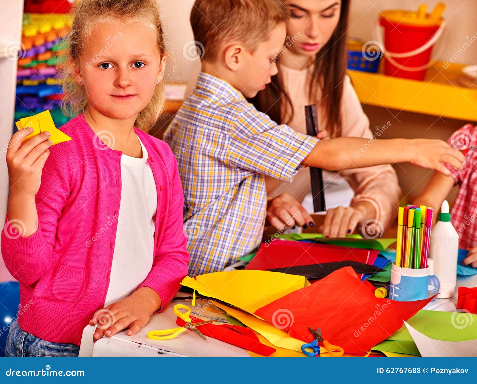 Kids Holding Colored Paper on Table in Stock Photo - Image of creative ...