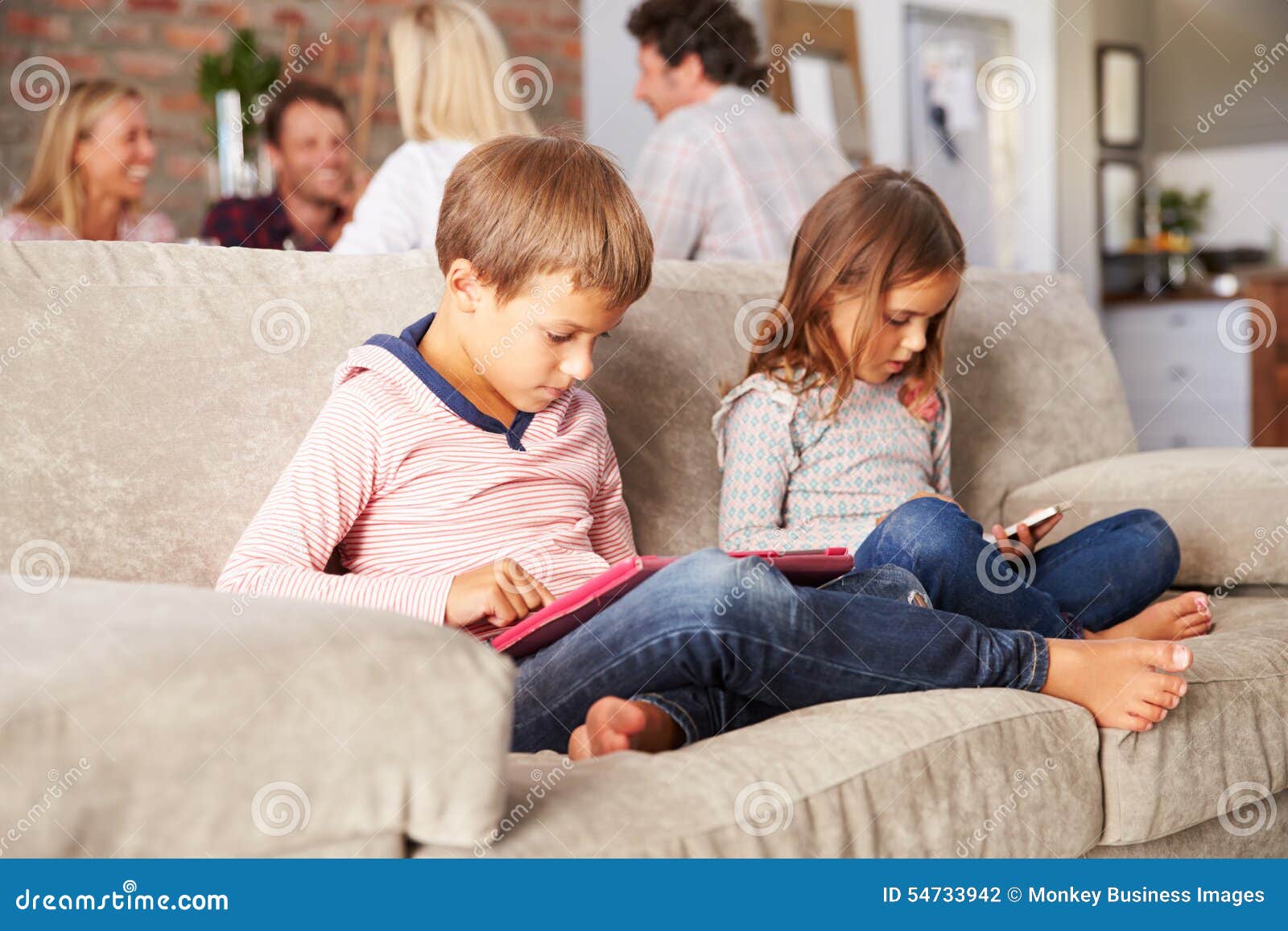 Kids Playing with New Technology while Adults Entertain Stock Photo ...