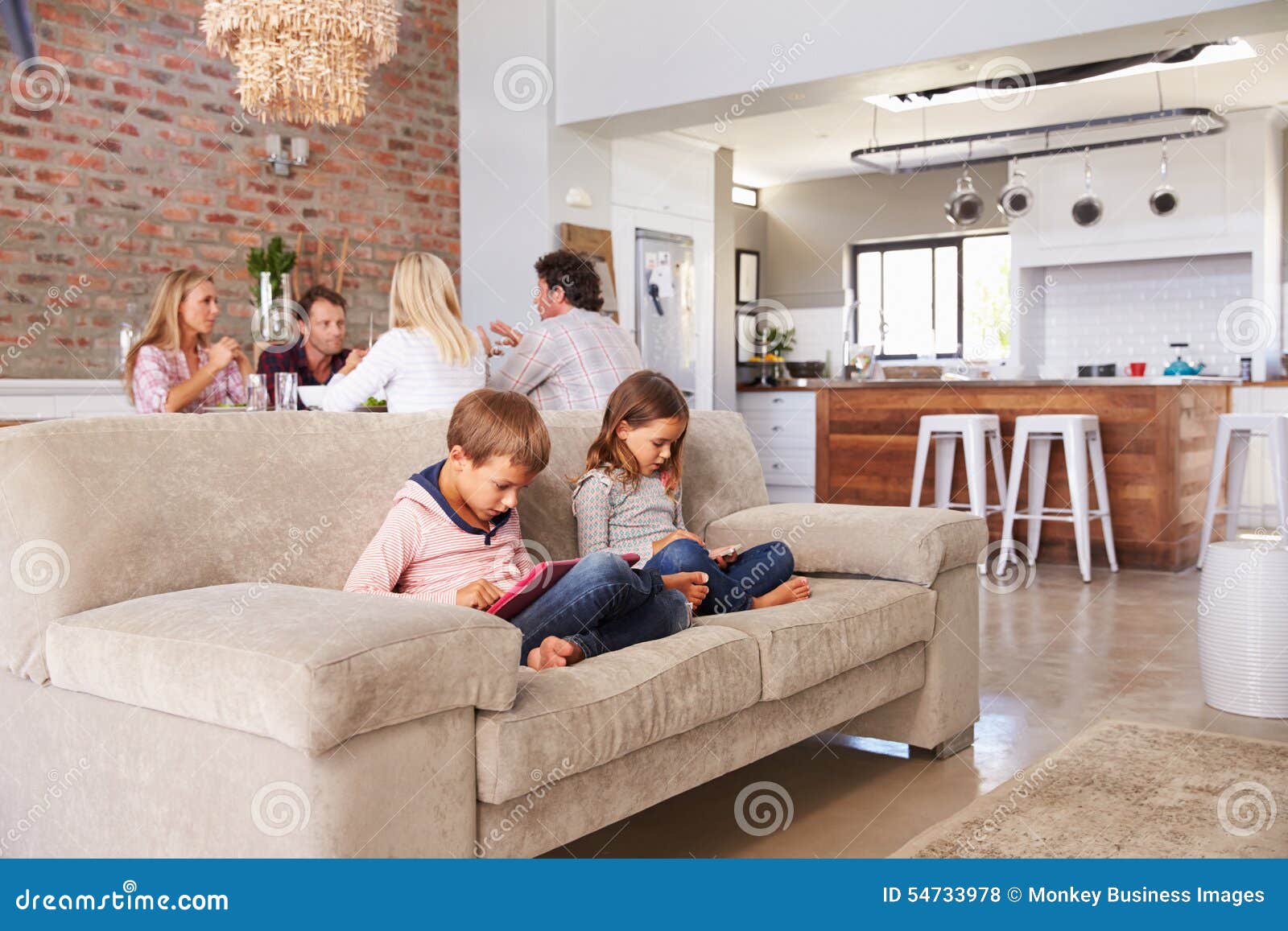 Kids Playing with New Technology while Adults Entertain Stock Photo ...