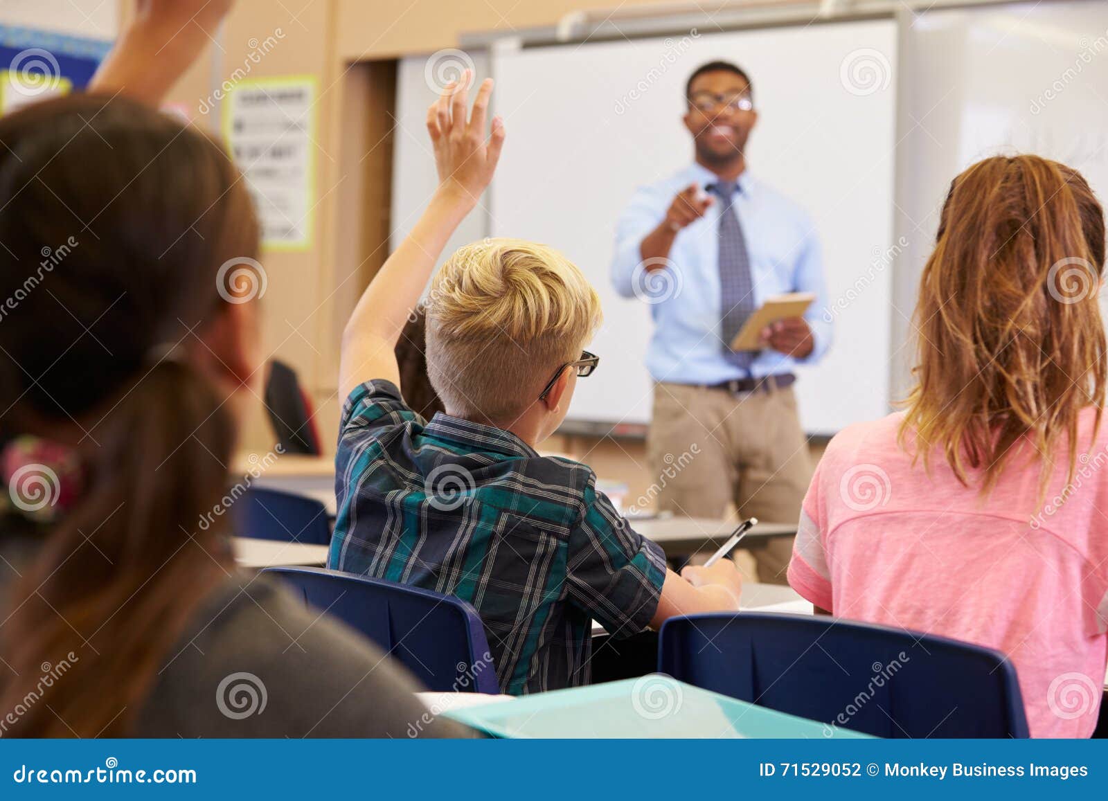 Kids Raising Hands To Answer in an Elementary School Class Stock Photo ...