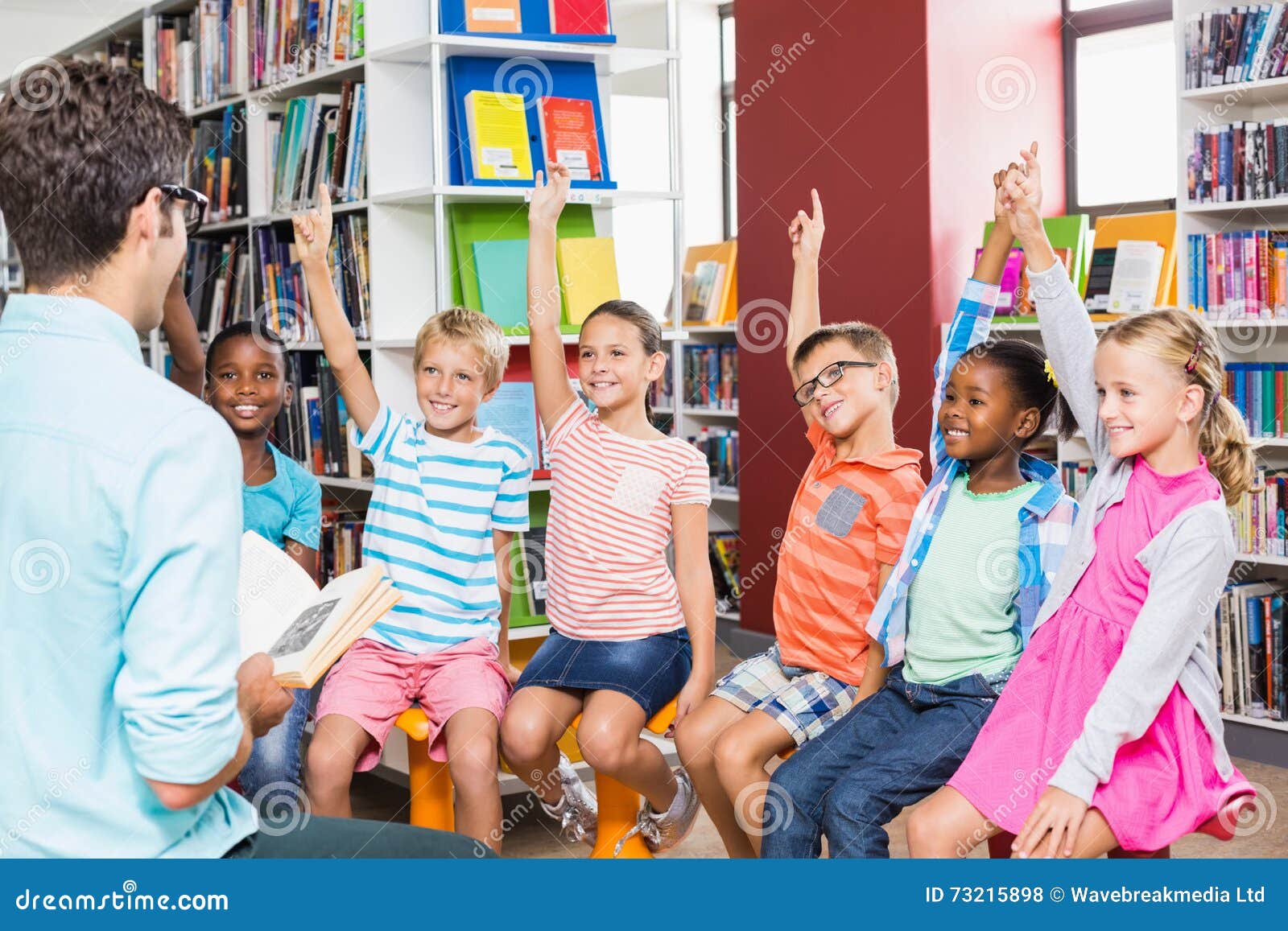 Kids Raising Their Hands in Library Stock Photo - Image of assisting ...