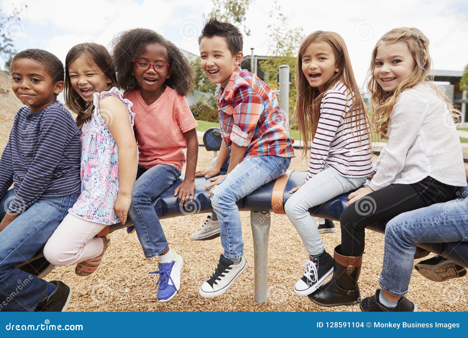 Kids Sitting on a Carousel in Their Schoolyard, Side View Stock Photo ...