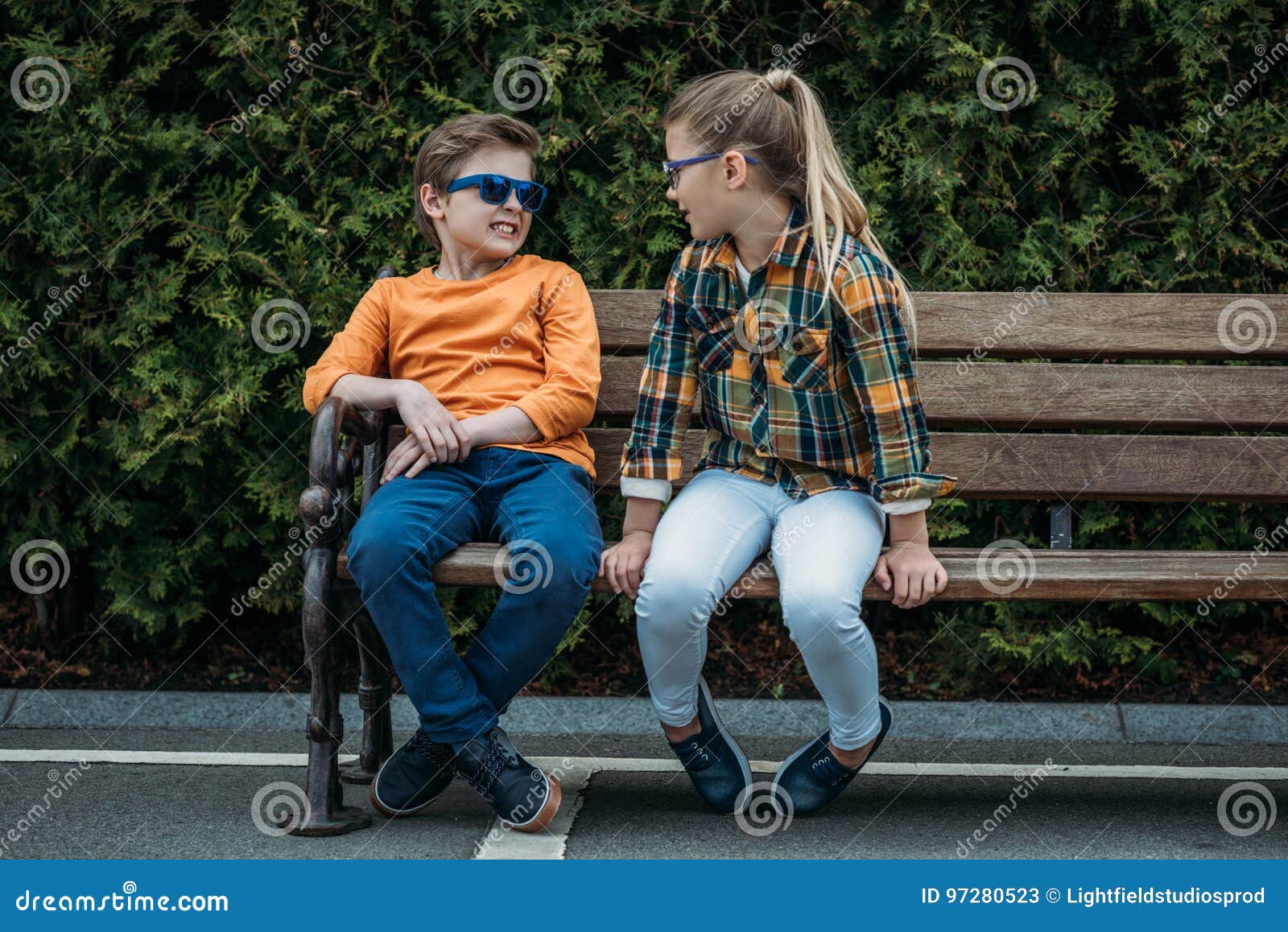 Kids in Sunglasses Talking while Sitting on Bench at Park Stock Image ...