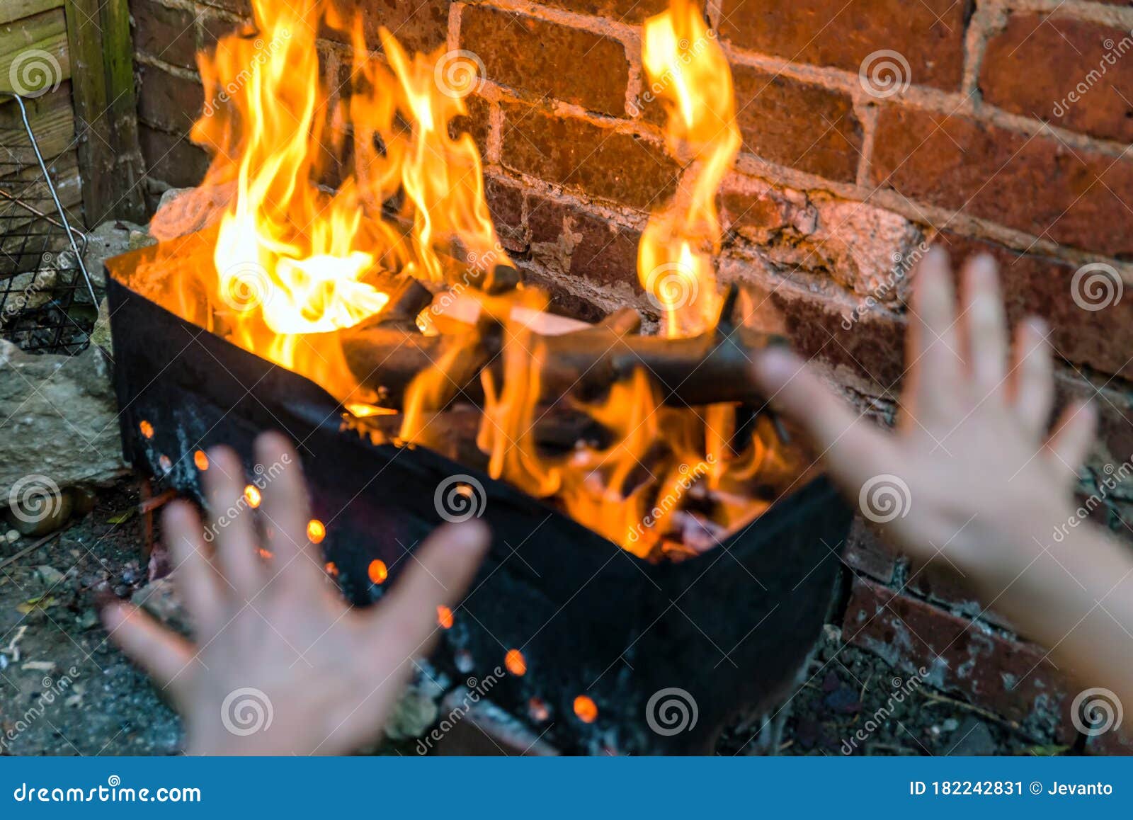 Kids Warming Their Arms Over Fire and Grill on Red Brick Wall ...