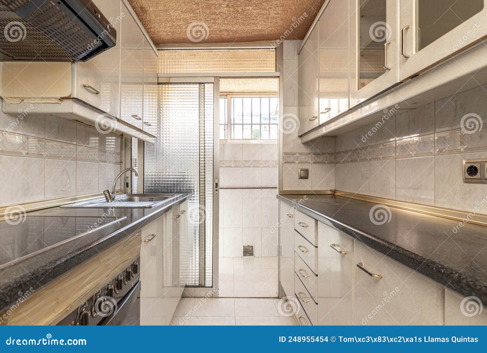 Kitchen with Furniture on Both Sides, with Black Countertop and Exit To ...