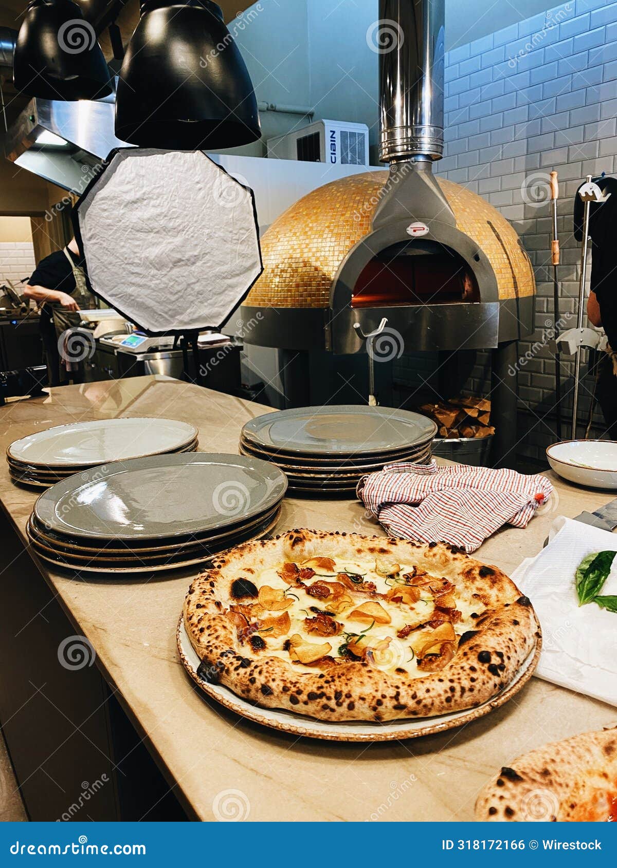 Kitchen Interior with Pizzas and Plates on Counters and Multiple Stoves ...