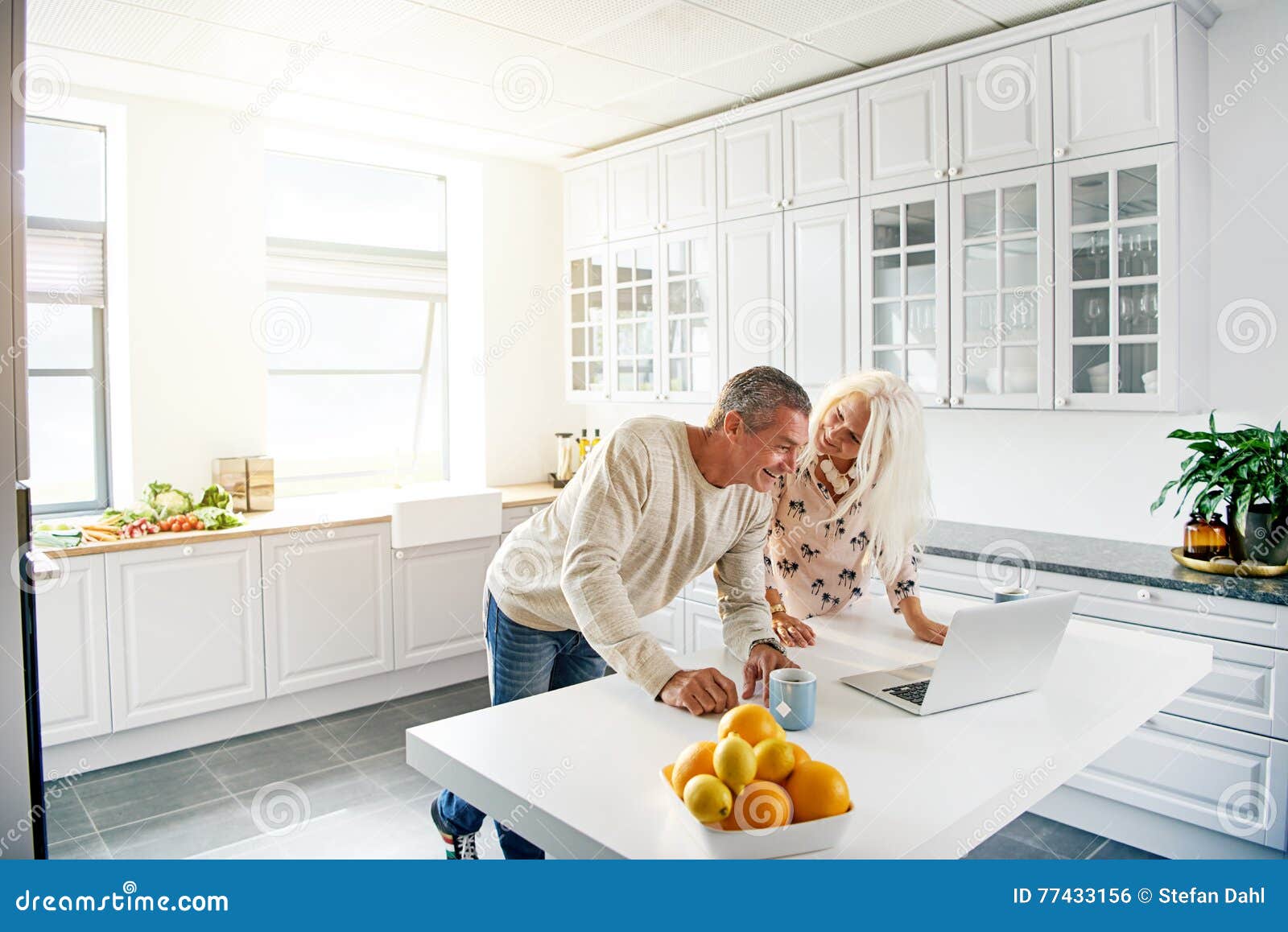 Kitchen Scene with Couple Looking at Computer Stock Photo - Image of ...