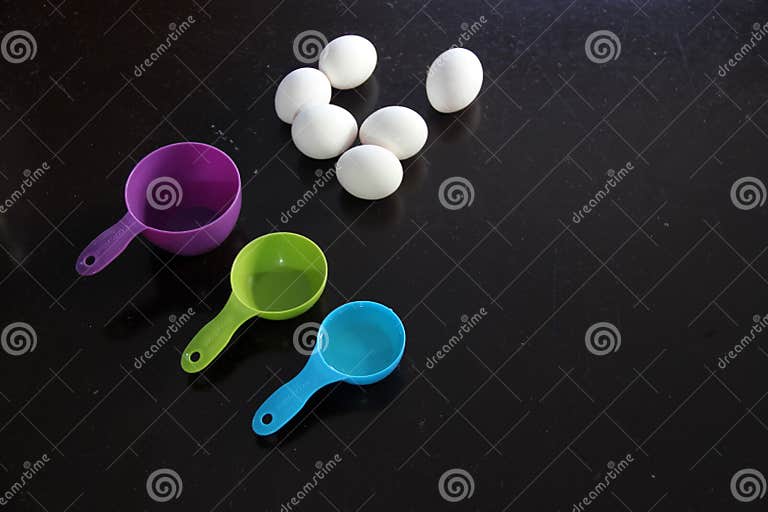Kitchen Utensils for Measuring and Eggs on Black Table Background Stock ...