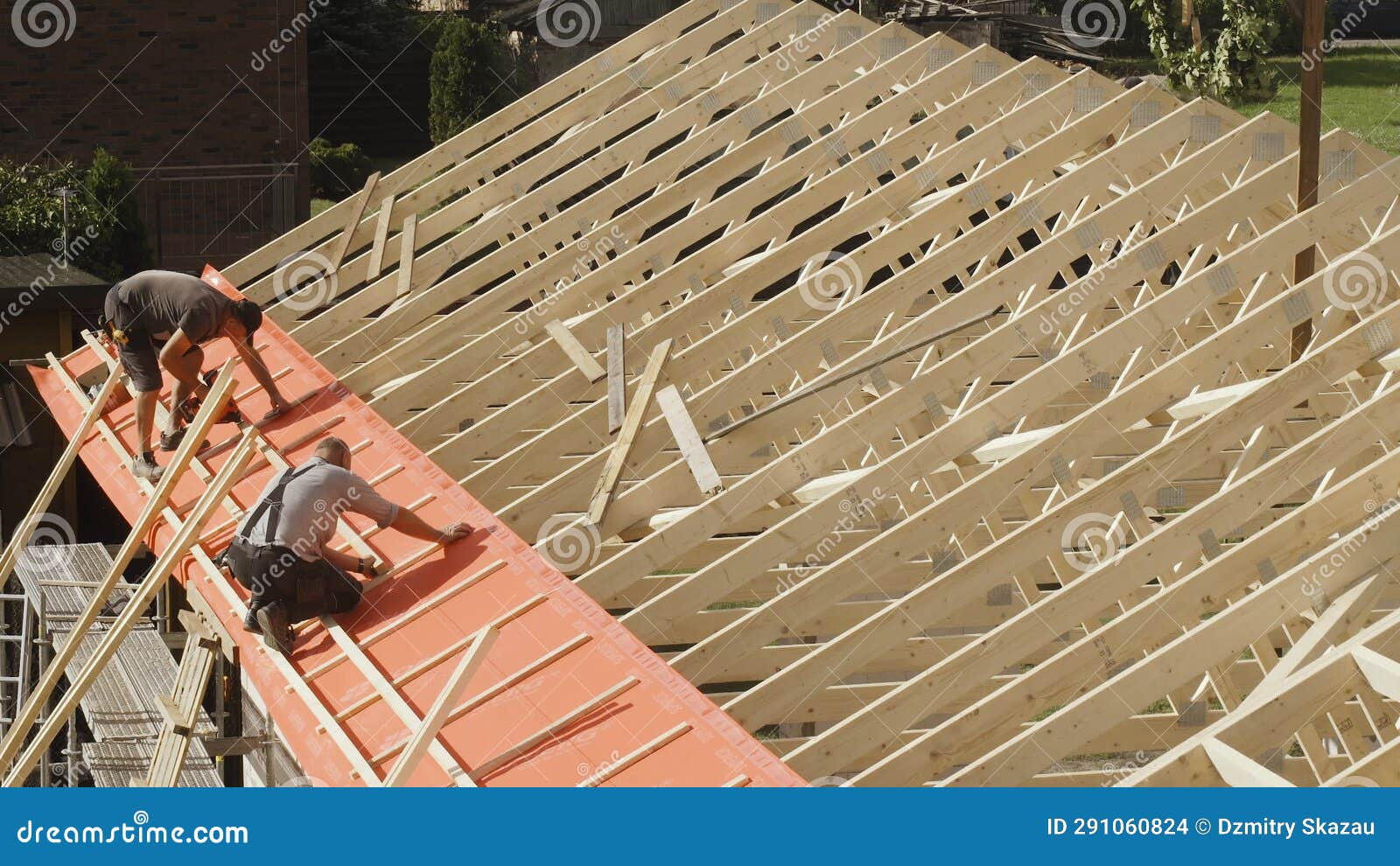 Workers Perform Installation Roofing Work on the Roof of the House ...