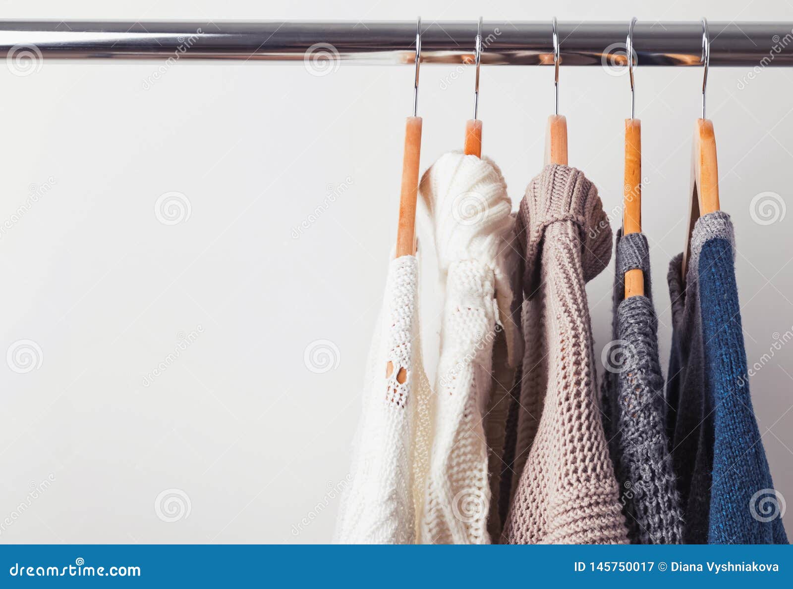 Knitted Sweaters on Hangers on the White Wall Background Stock Image ...
