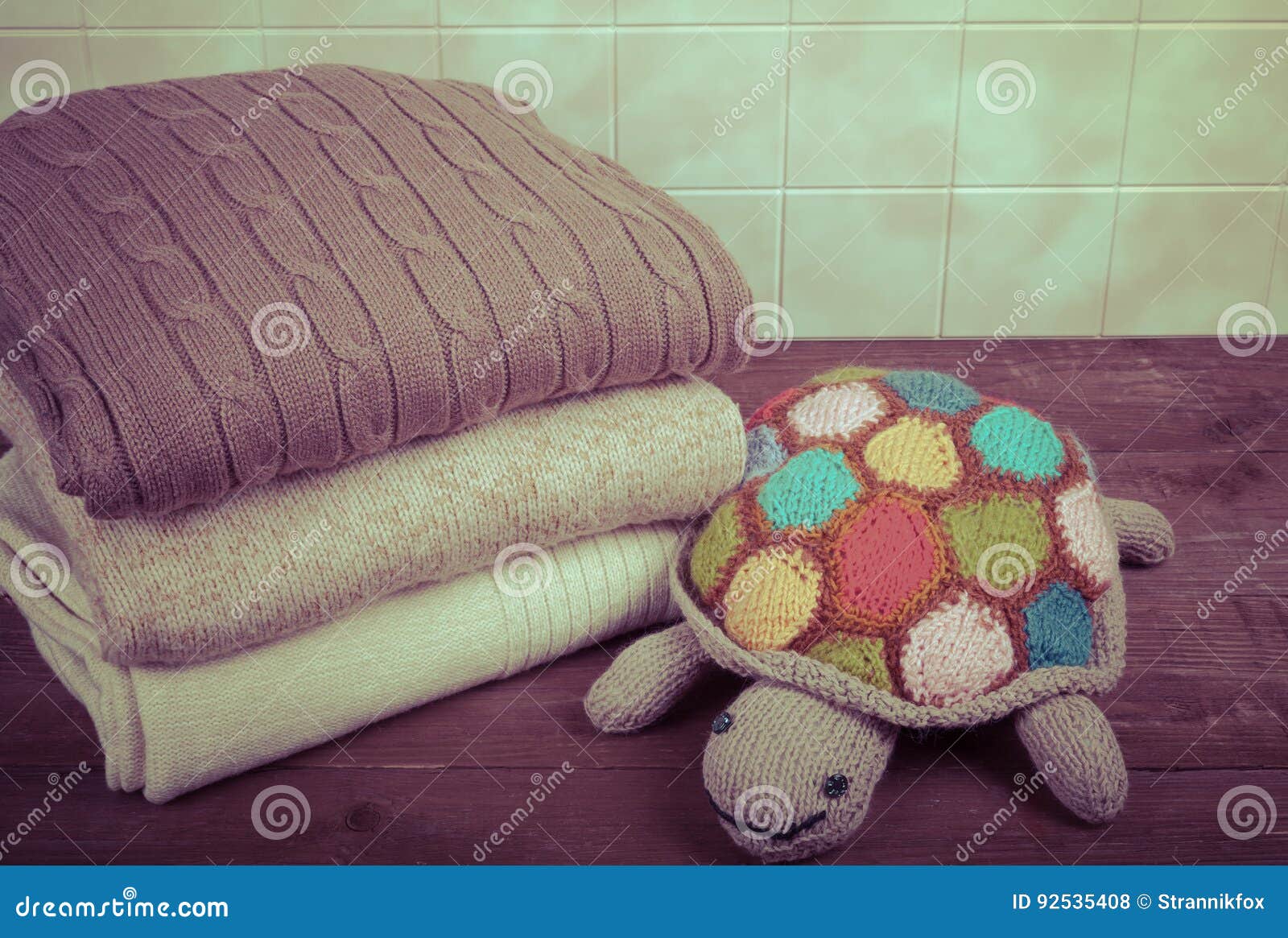 Knitted Toy Turtle with the Stack of Knitted Clothes on Wooden T Stock ...