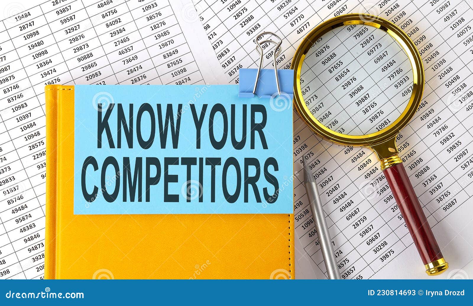 KNOW YOUR COMPETITORS Text on Sticker on Notebook with Magnifier and ...