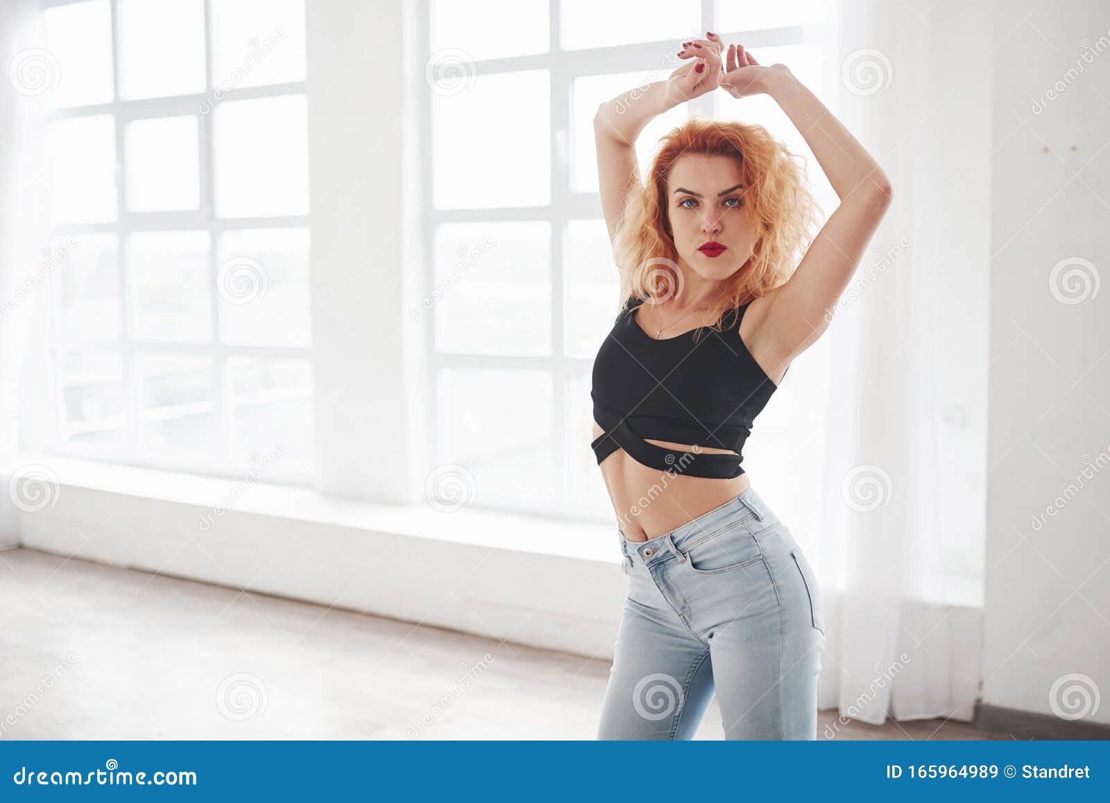 She Knows How To Move Attractive Redhead Woman Posing In The Spacey Room Near The Window Stock