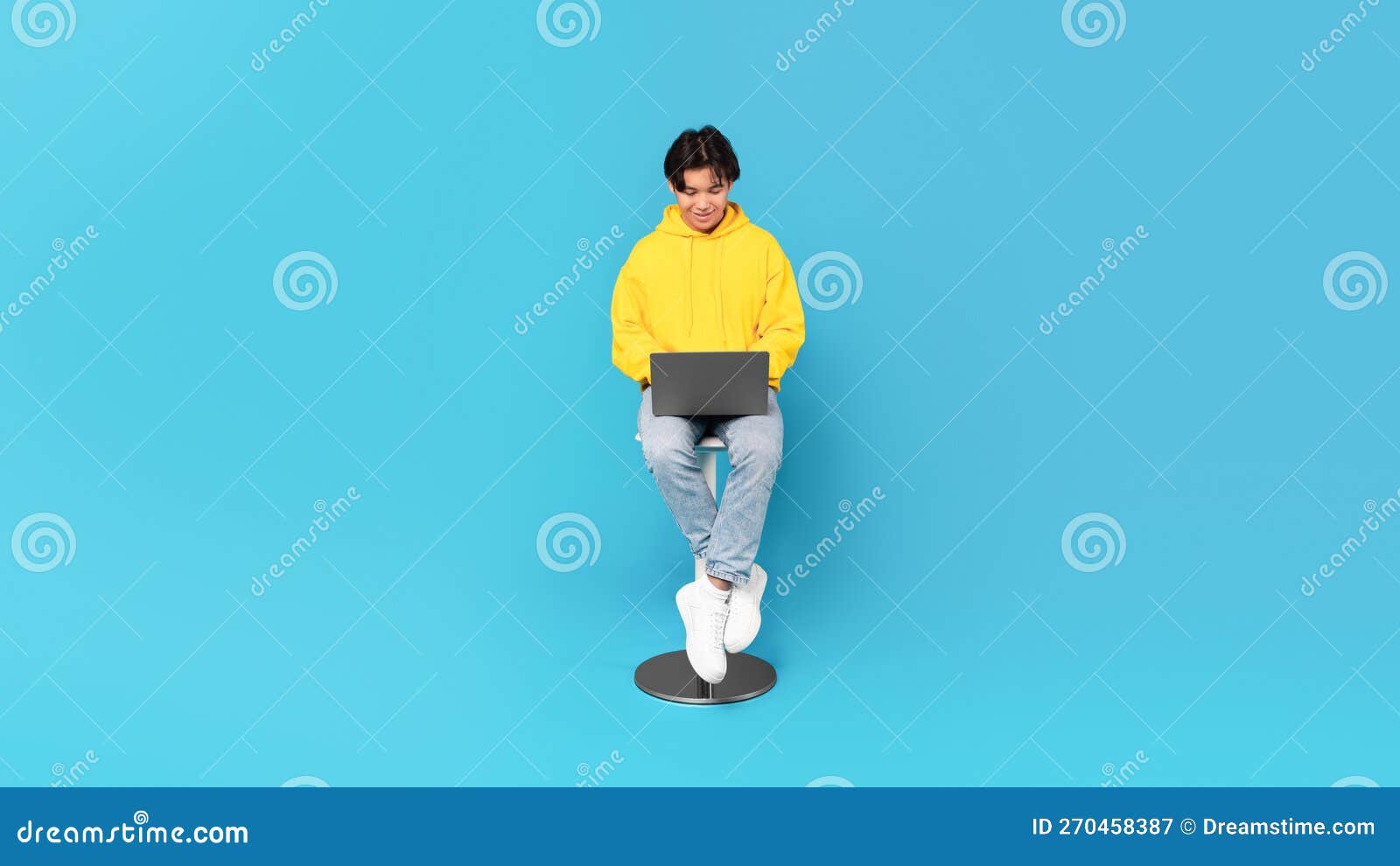 Korean Teen Guy Using Laptop Sitting Over Blue Studio Background Stock ...