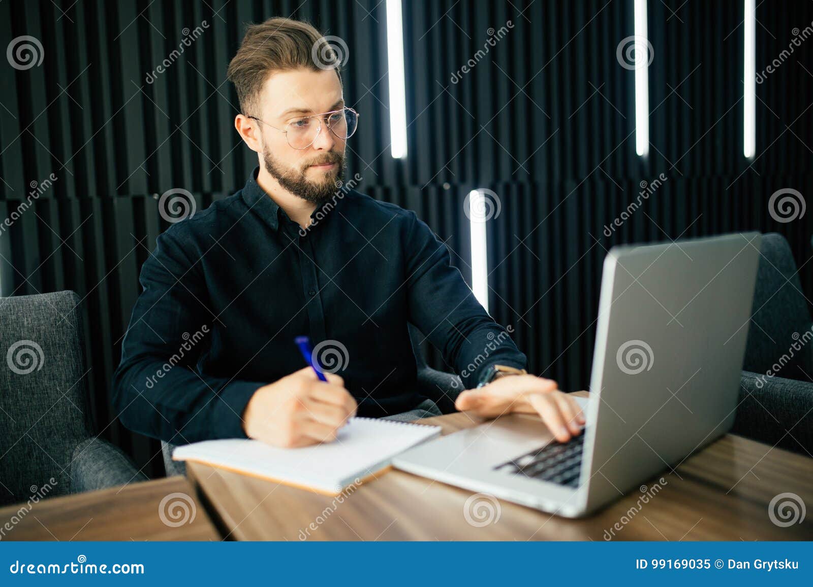 L'uomo D'affari Sorridente Con Il Computer Portatile E Scrive L'avviso ...