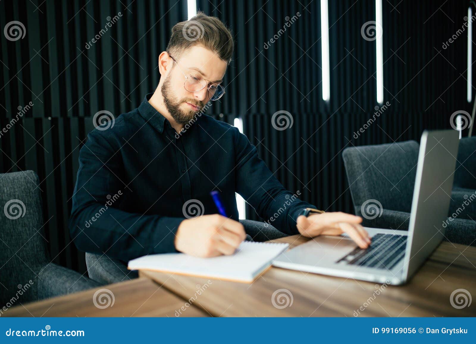 L'uomo D'affari Sorridente Con Il Computer Portatile E Scrive L'avviso ...