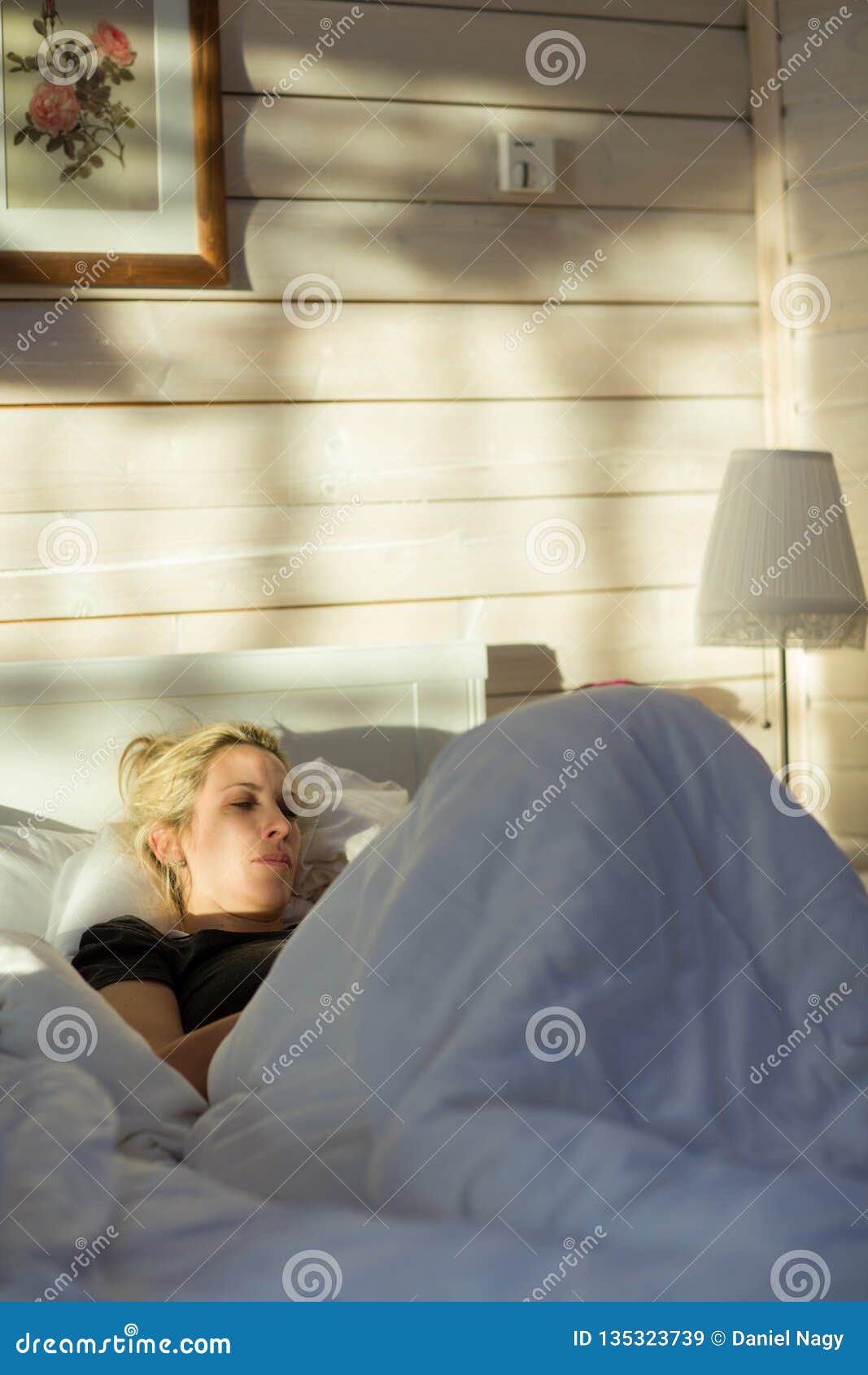 La Bella Donna Bionda Si Situa E Legge a Letto Immagine Stock ...
