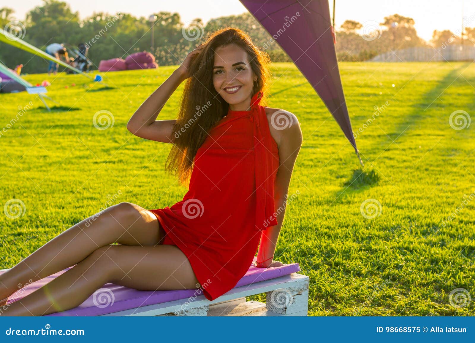 La Belle Jeune Femme De Brune Avec De Longs Cheveux Dans Une Robe Rouge