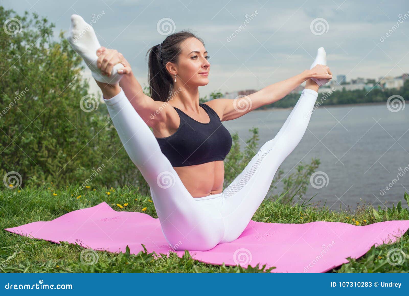 La Femme Tenant Faire Distant De Jambes Exerce Laérobic Réchauffant Avec La Gymnastique Pour La