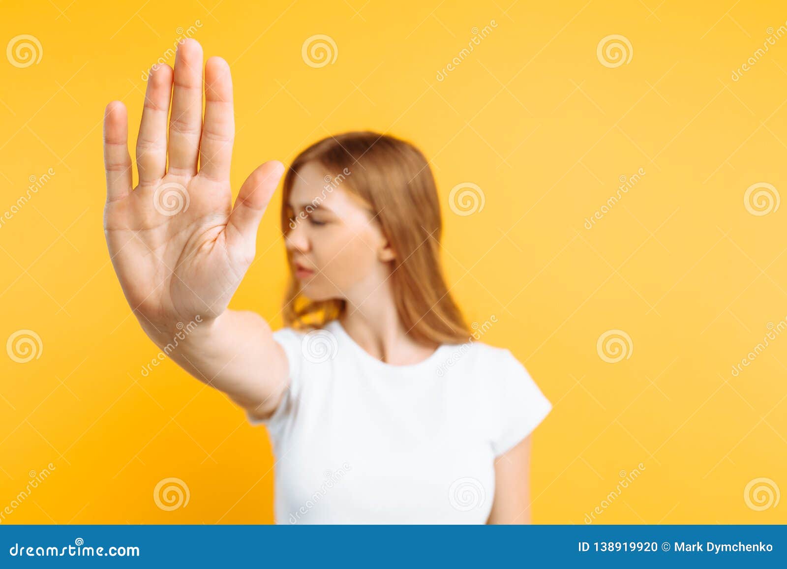La Giovane Ragazza Seria Mostra Un Gesto Ostile Su Un Fondo Giallo ... La Giovane Ragazza Seria Mostra Un Gesto Ostile Su Un Fondo Giallo ...