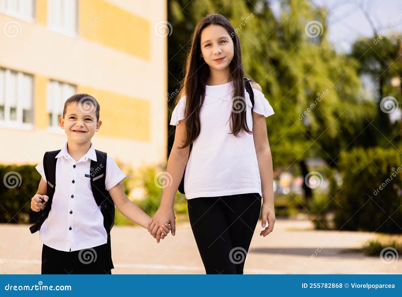 La Hermana Mayor Cuida Al Hermano Menor Sujeta Su Mano Y Van A La Escuela Foto De Archivo