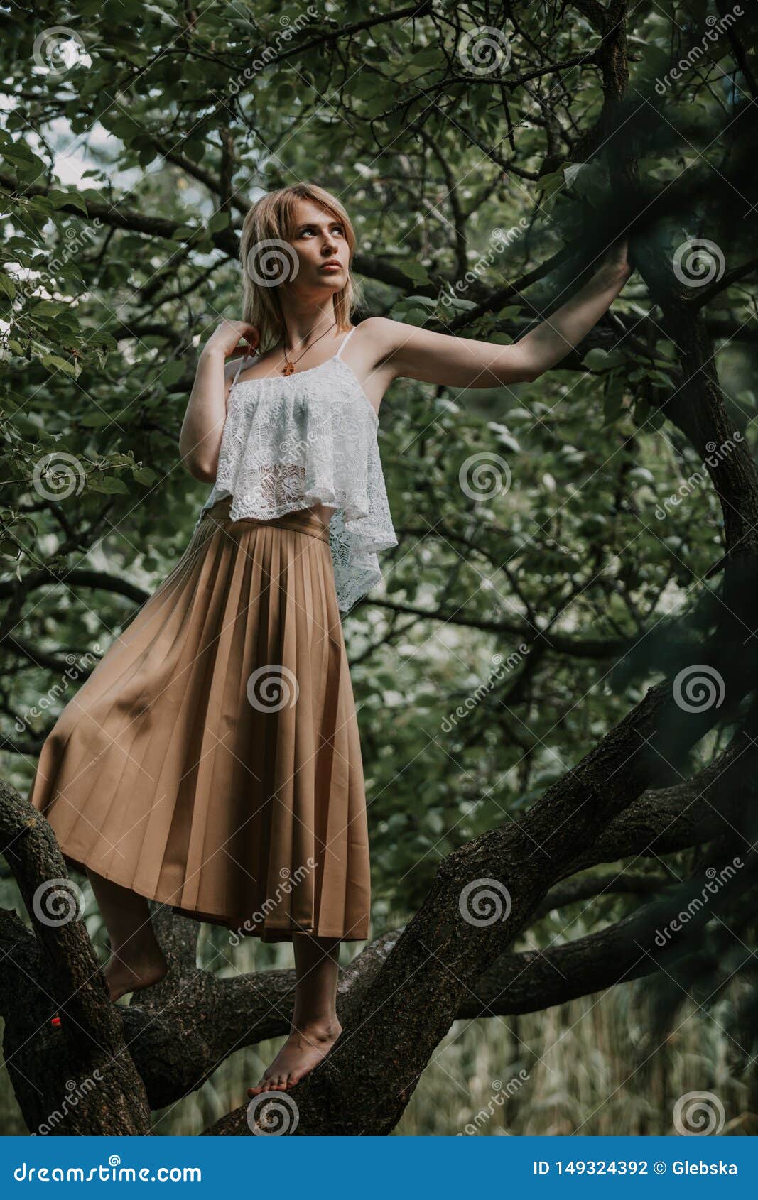 La Jolie Blonde Se Tient Nu Pieds Sur La Branche Darbre Photo Stock