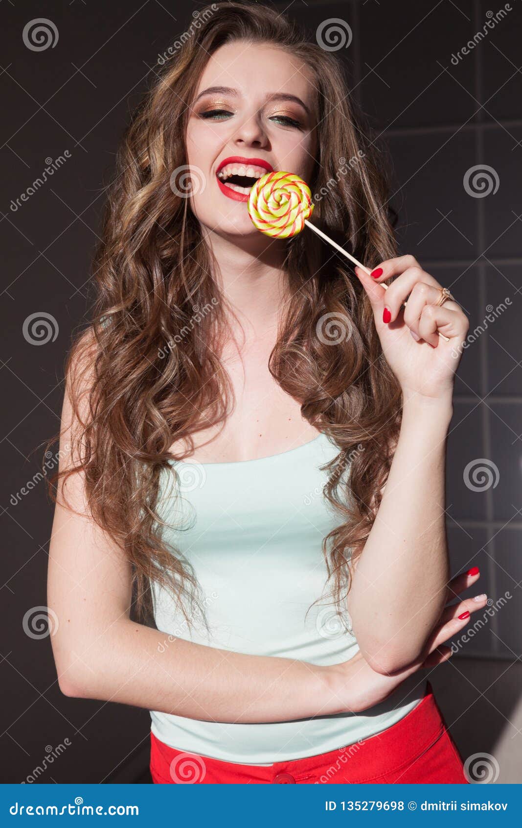 La Jolie Fille Mange Une Sucrerie Douce De Lucette De Sucrerie Photo