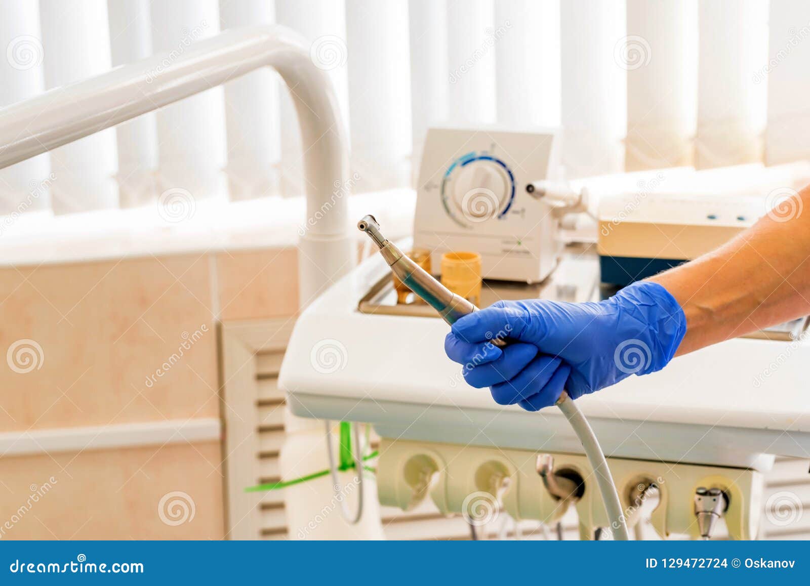 La Main Du Dentiste Dans Le Gant Tient La Machine Dentaire De Perceuse ...