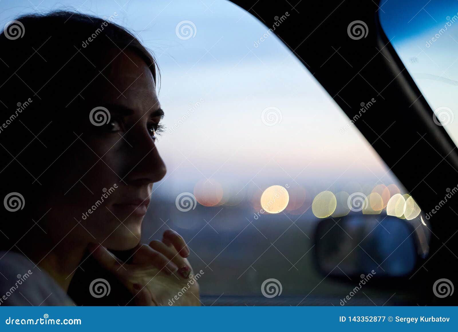 La Mujer Se Sienta En Un Coche En El Fondo De Las Luces De La Ciudad Noche De La Tarde Imagen De