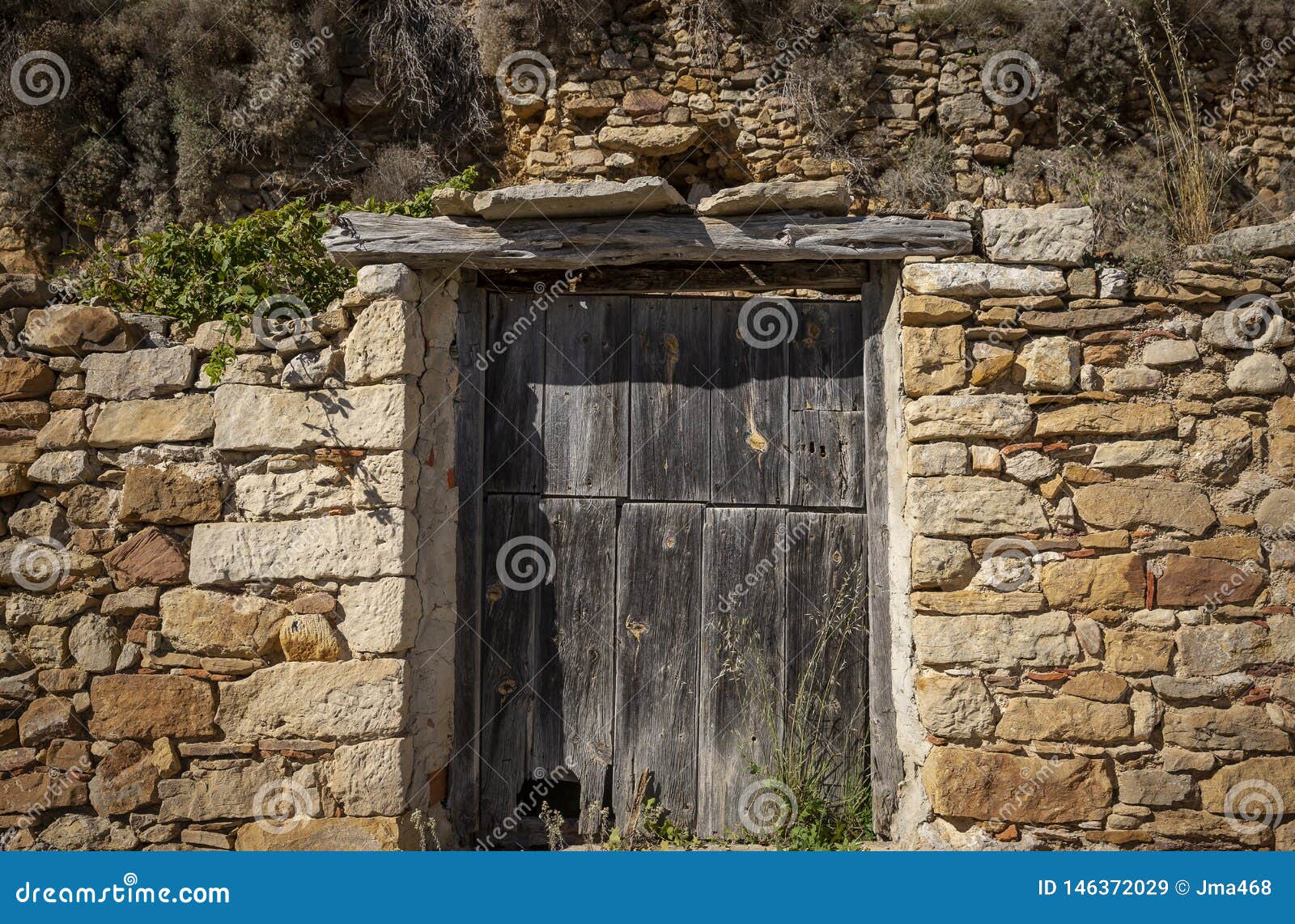 La Puerta De Madera Antigua En Una Piedra Antigua Hizo La Pared Imagen