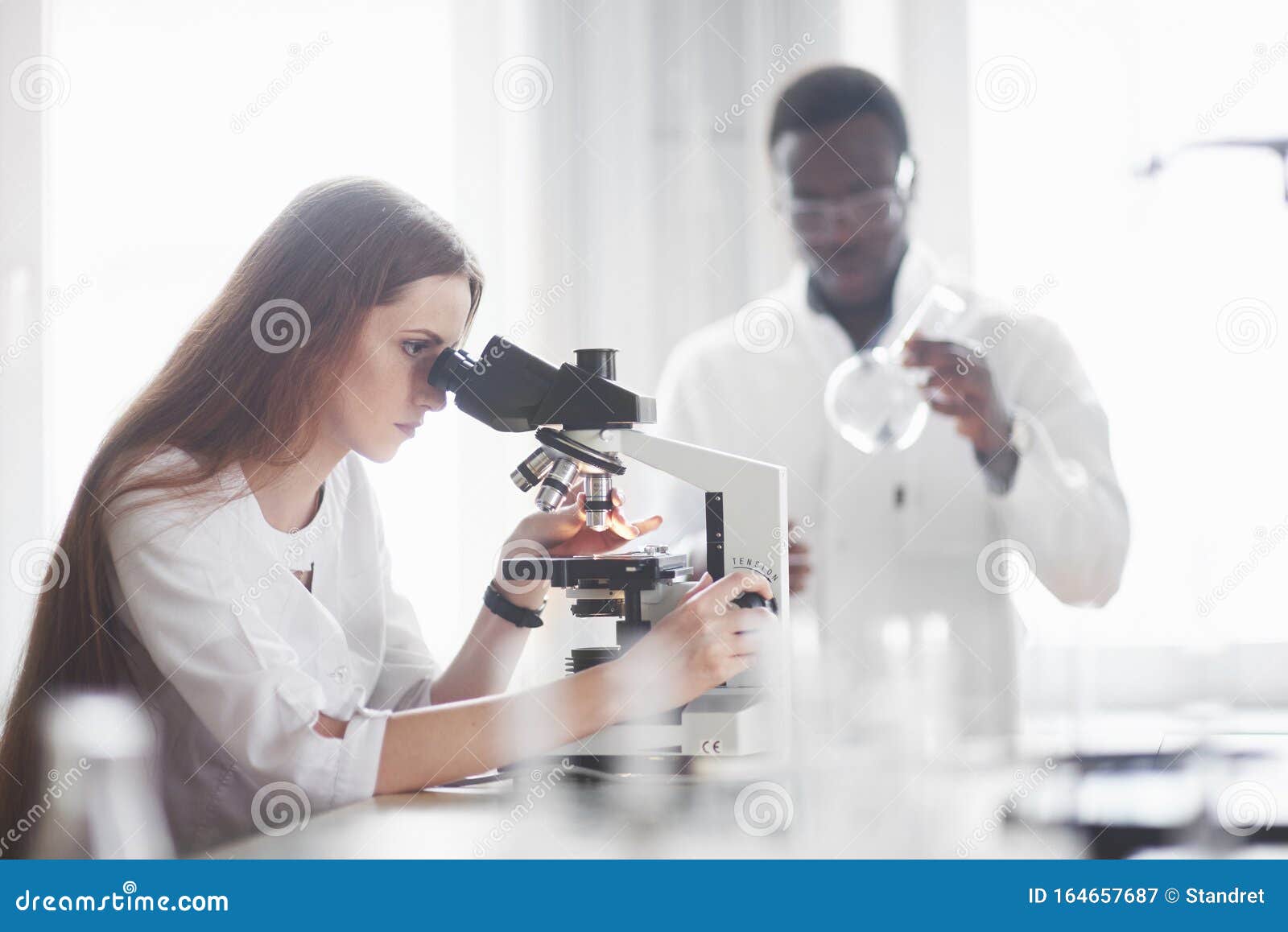 Lab Assistant with Microscope Laboratory Glassware Bulb with Chemicals ...