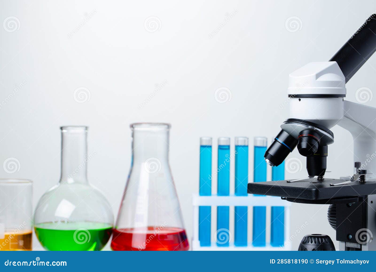 Lab Microscope with Laboratory Glassware on Desk Against White ...
