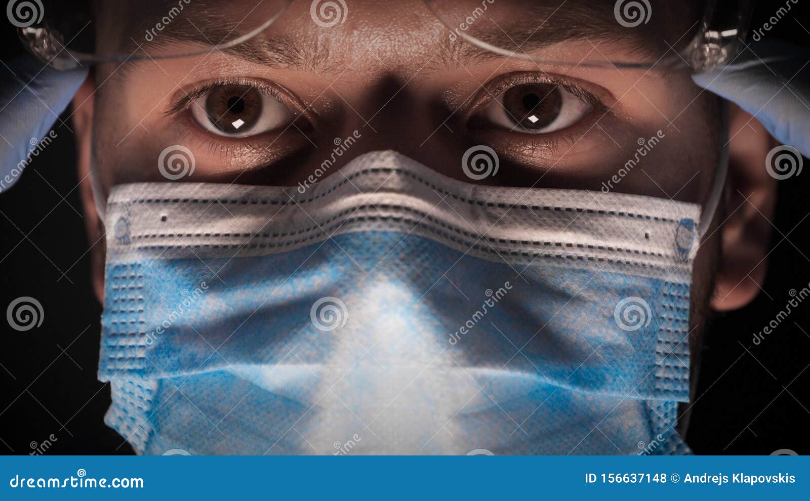 A Lab Worker in a Mask Puts on Protective Work Glasses for Working in ...