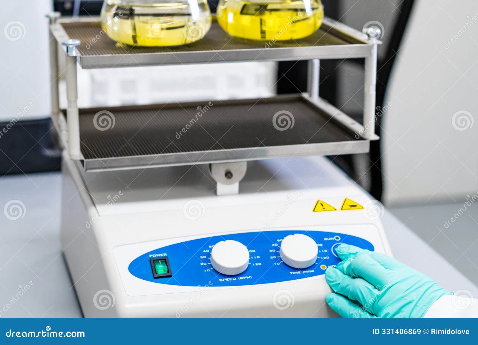 Lab Worker in Rubber Gloves Switches on the Laboratory Shaker in the ...